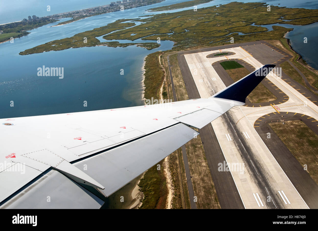 View of aircraft wing passing over end of a runway after taking off ...
