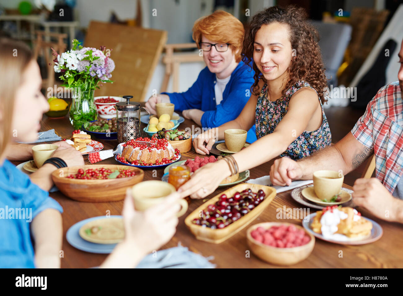 Friends by festive table Stock Photo - Alamy