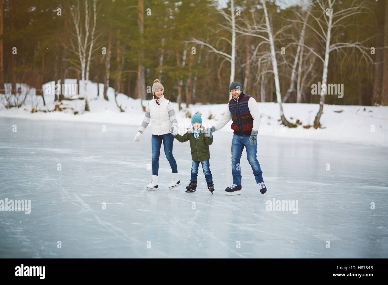 Family portrait on skating rink Stock Photo - Alamy