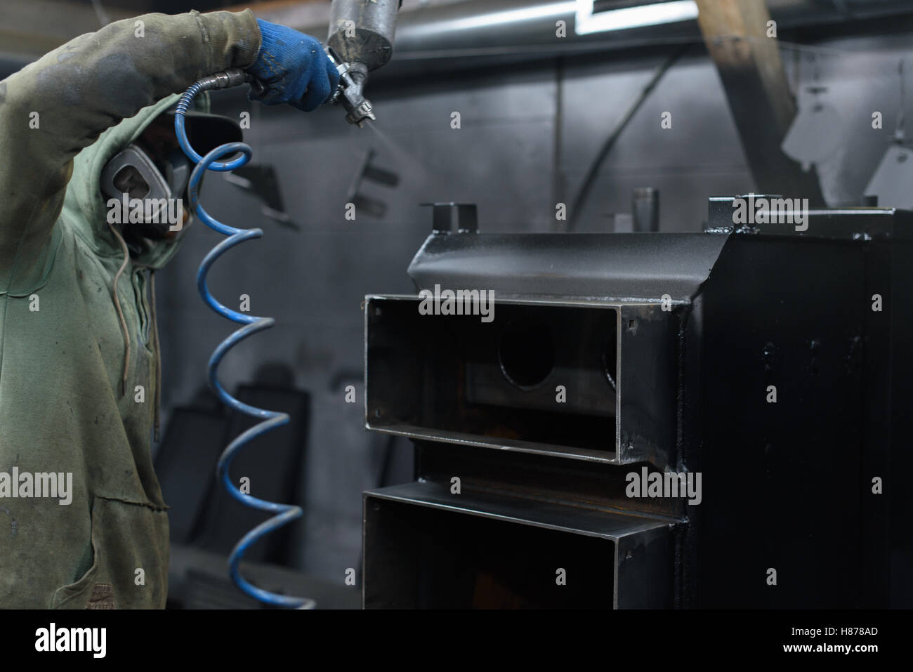 Man in working suit paints solid fuel boiler on the plant Stock Photo ...