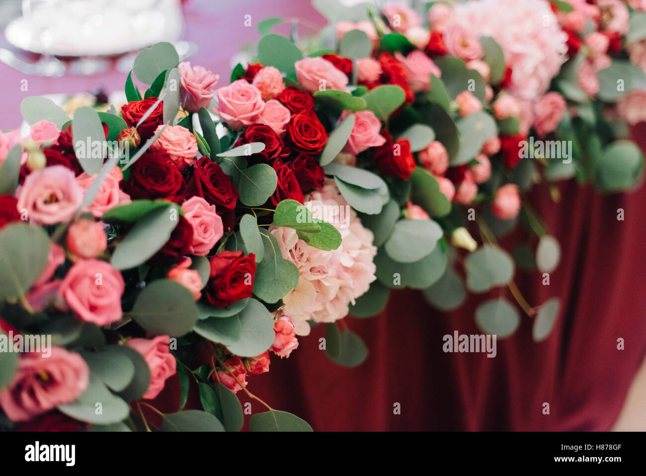 Flower festoon with wonderful roses lies on red dinner table Stock ...