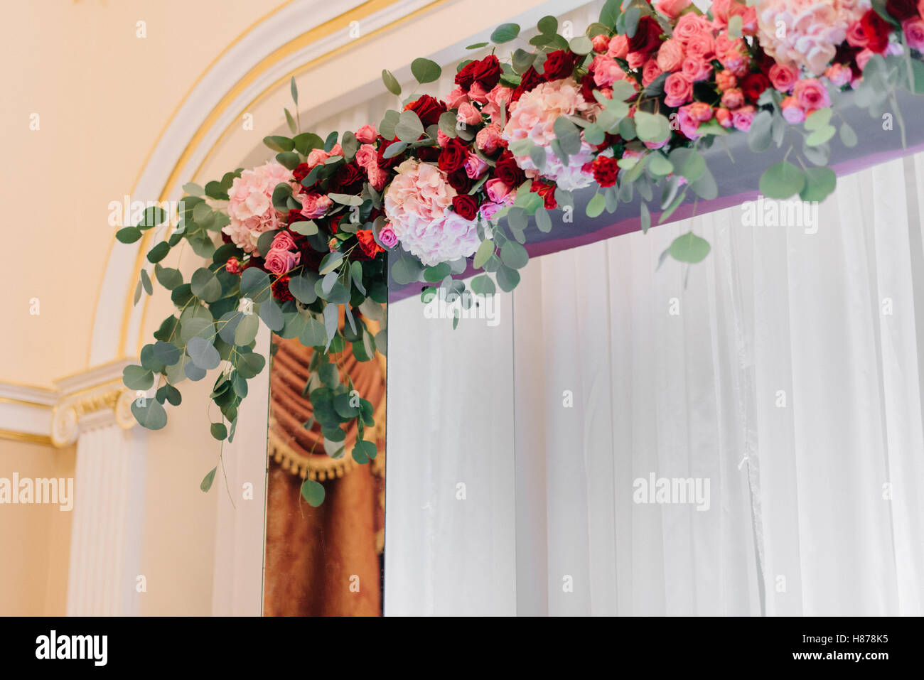 Large flower garland of red roses hangs on the window Stock Photo - Alamy