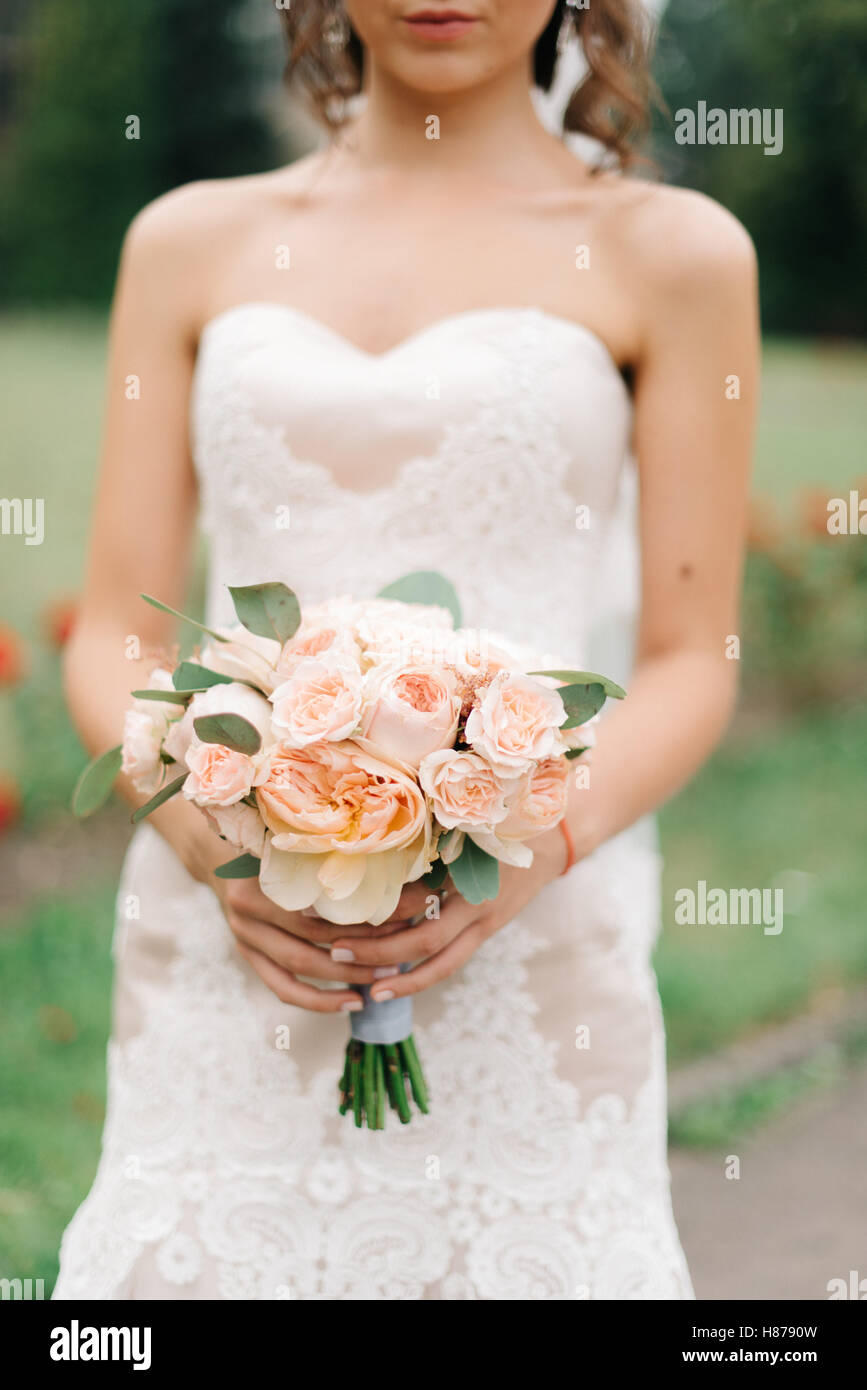Elegant bride holds peach wedding bouquet Stock Photo - Alamy