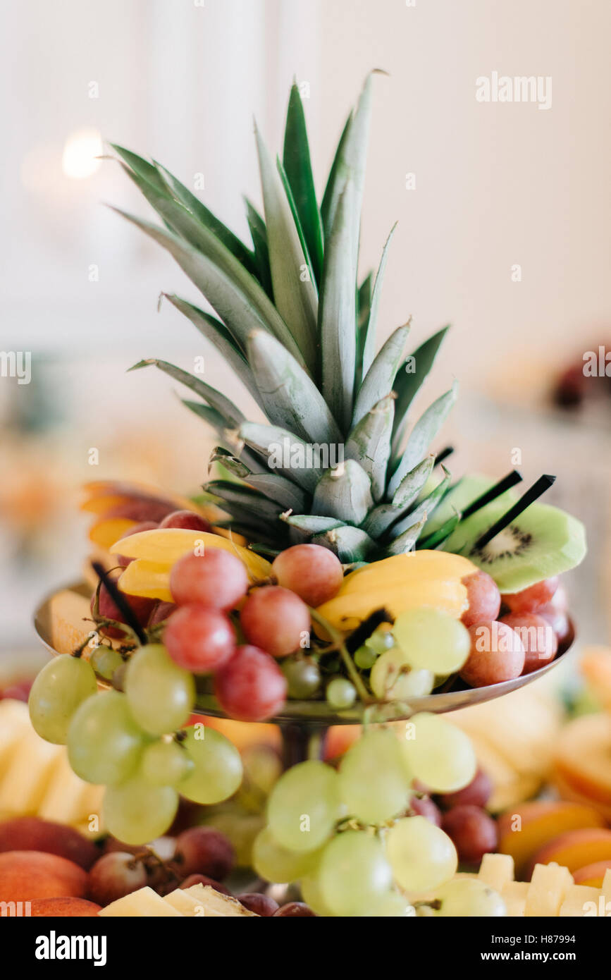 Cut ananas and other fruits stand served on steel dish Stock Photo - Alamy