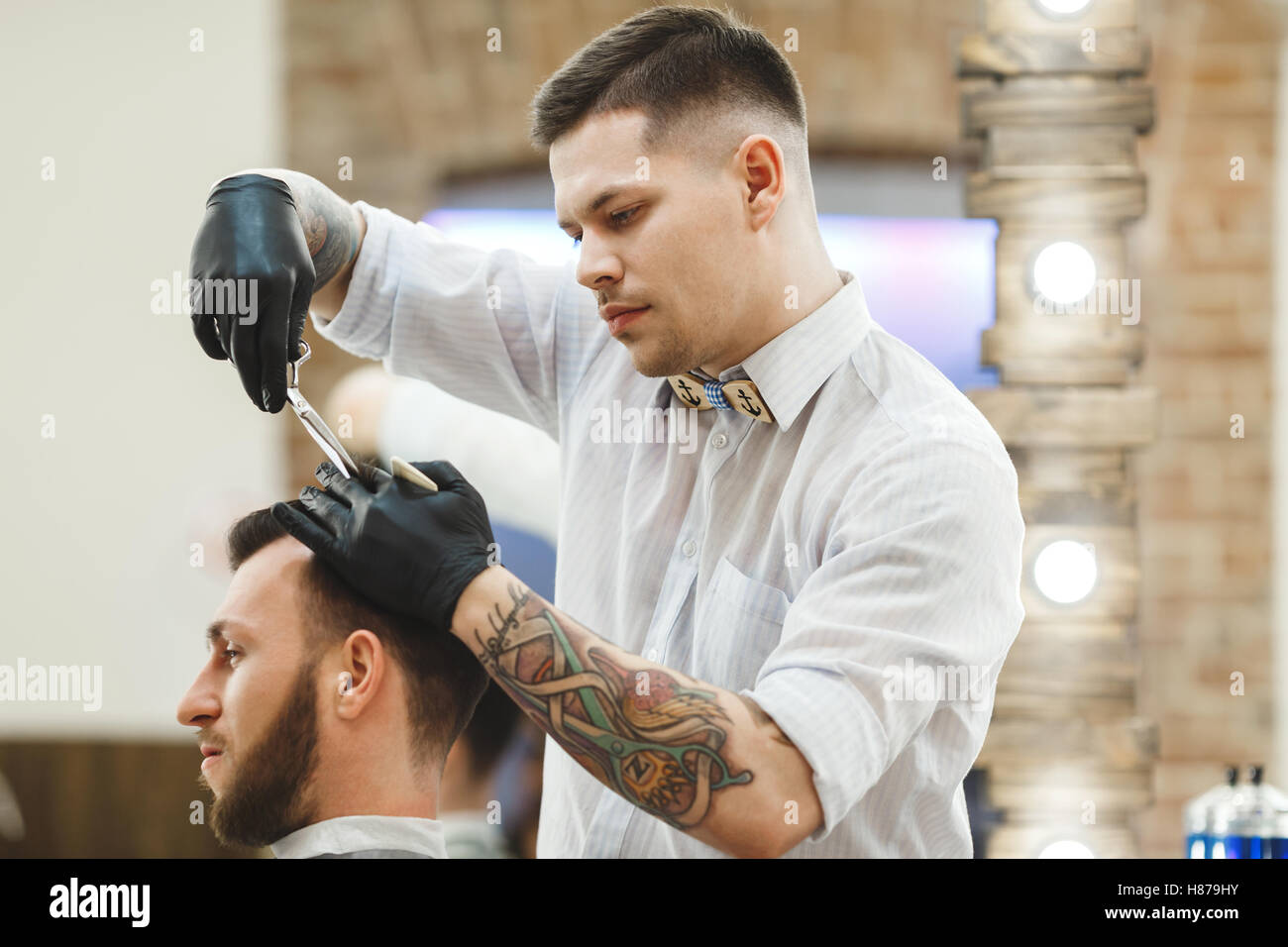 Barber doing haircuts for client Stock Photo - Alamy