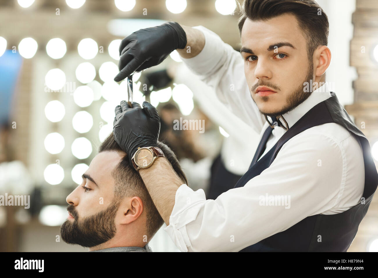 Barber doing haircuts for client Stock Photo - Alamy
