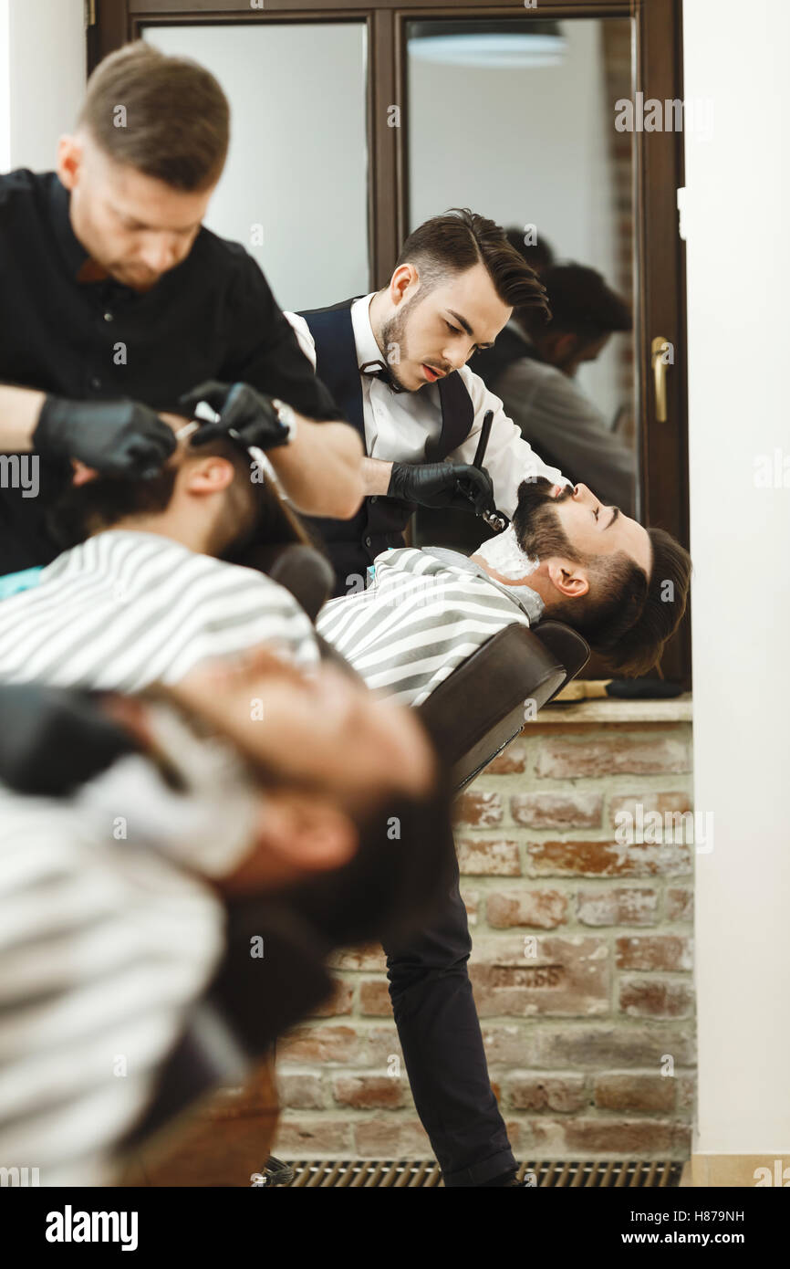 Barbers making a beard form for clients Stock Photo - Alamy