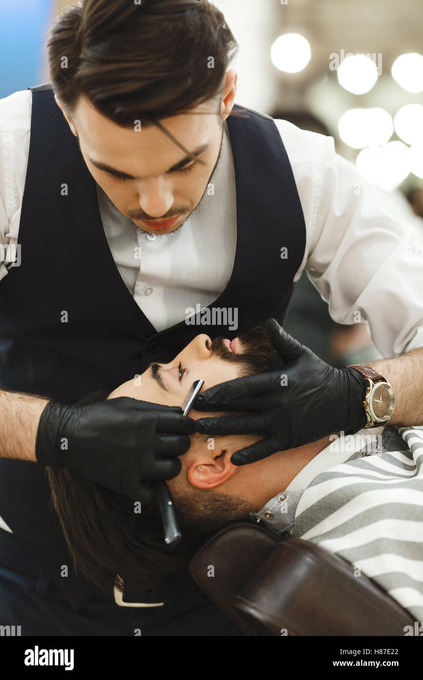 Barber making beard form for man Stock Photo - Alamy