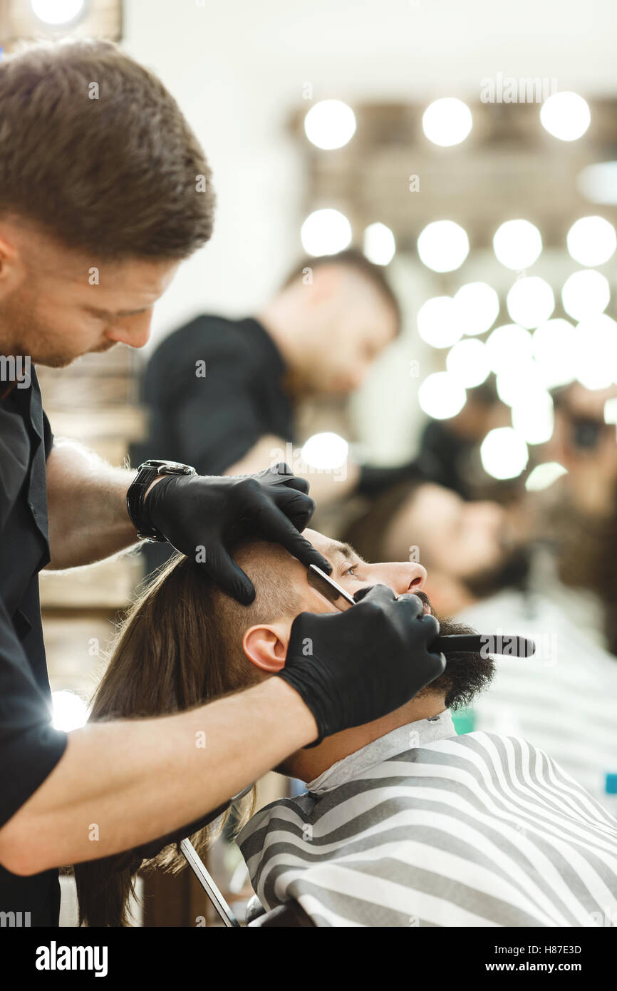 Barber making beard form for man Stock Photo - Alamy