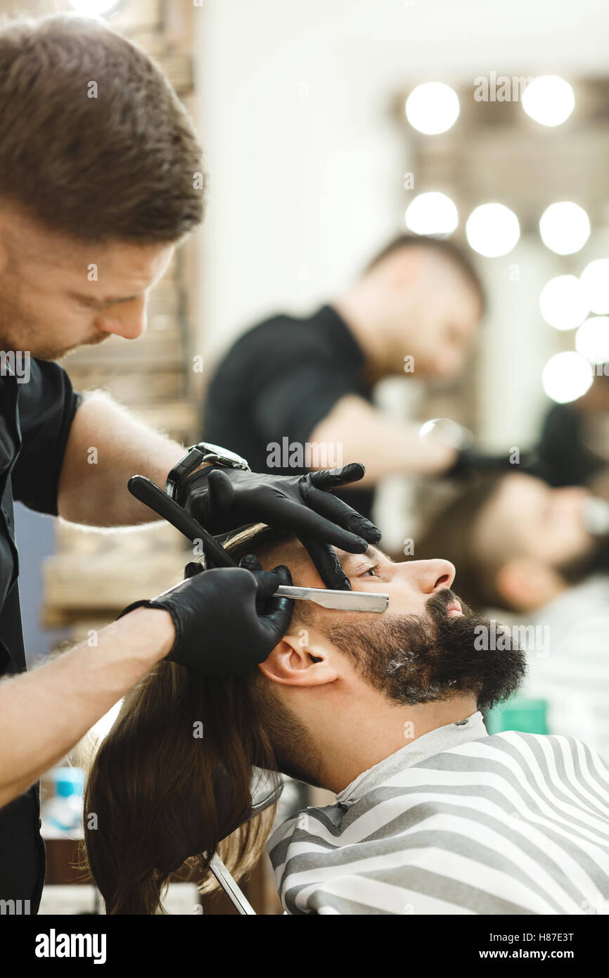 Barber making beard form for man Stock Photo - Alamy