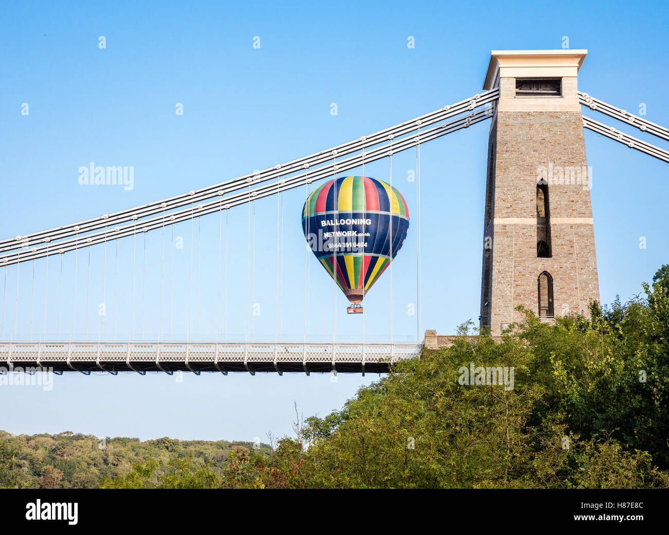 A hot air balloon dropping behind the Clifton suspension bridge in ...