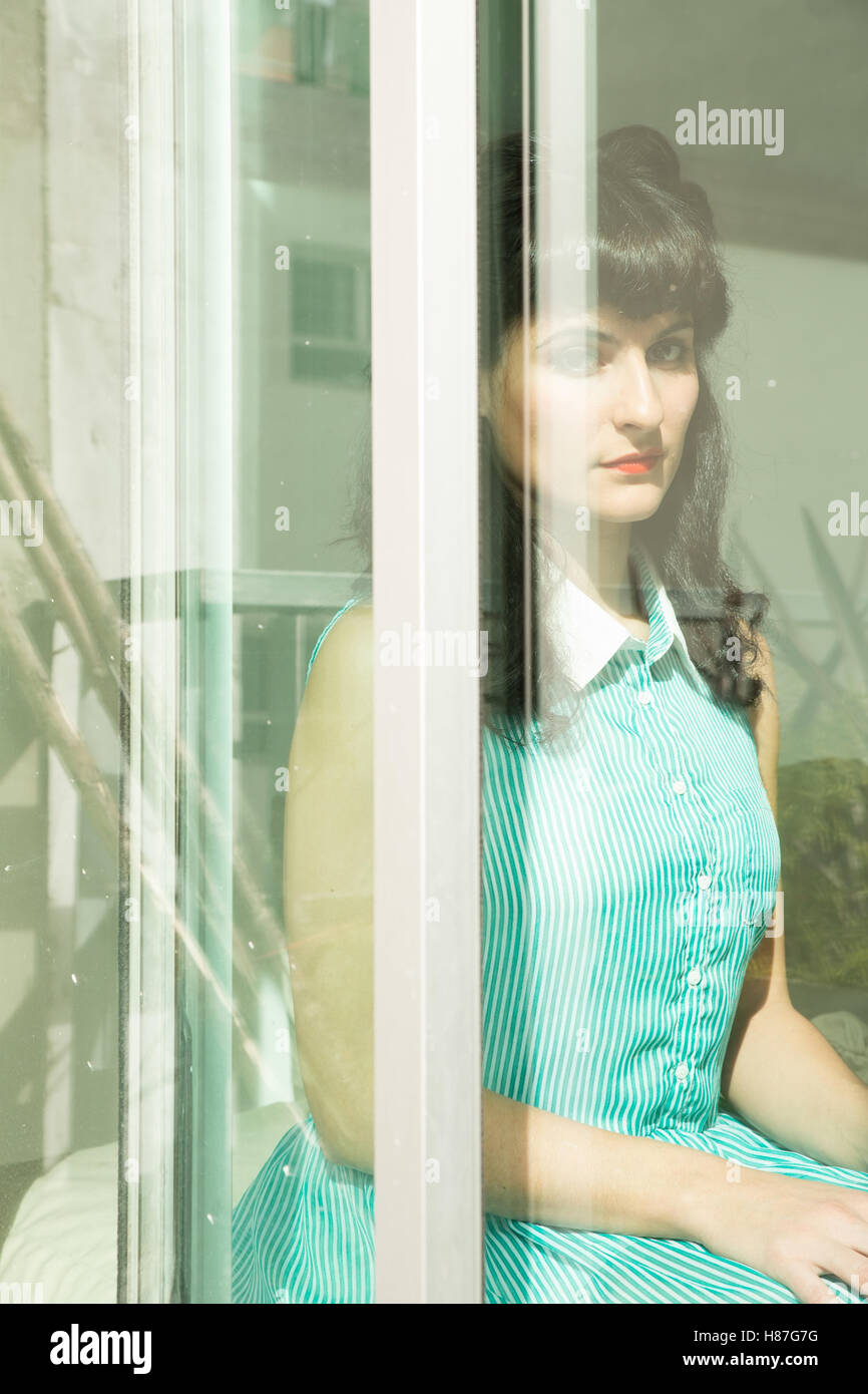 A vintage styled woman sitting beside the window Stock Photo - Alamy