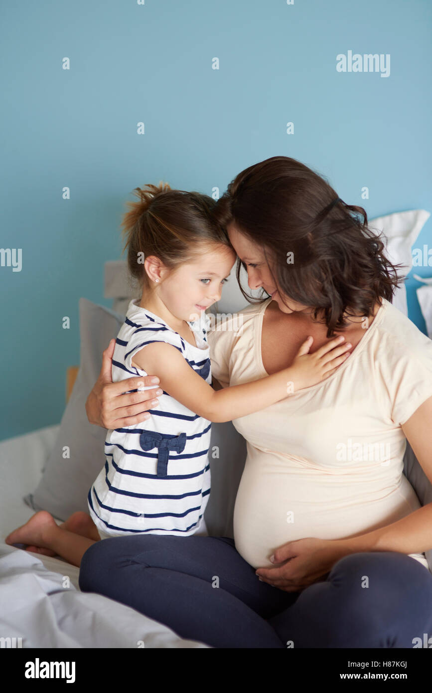 Mom and daughter embracing in bed Stock Photo - Alamy