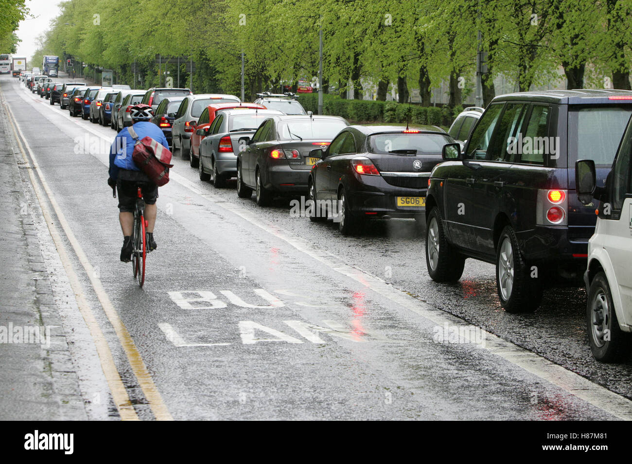 Cyclist passing traffic in rush hour Stock Photo - Alamy