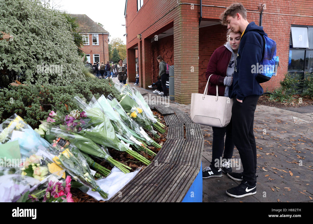 Molly Kay 17, and Liam Owers, 16, look at floral tributes left by ...