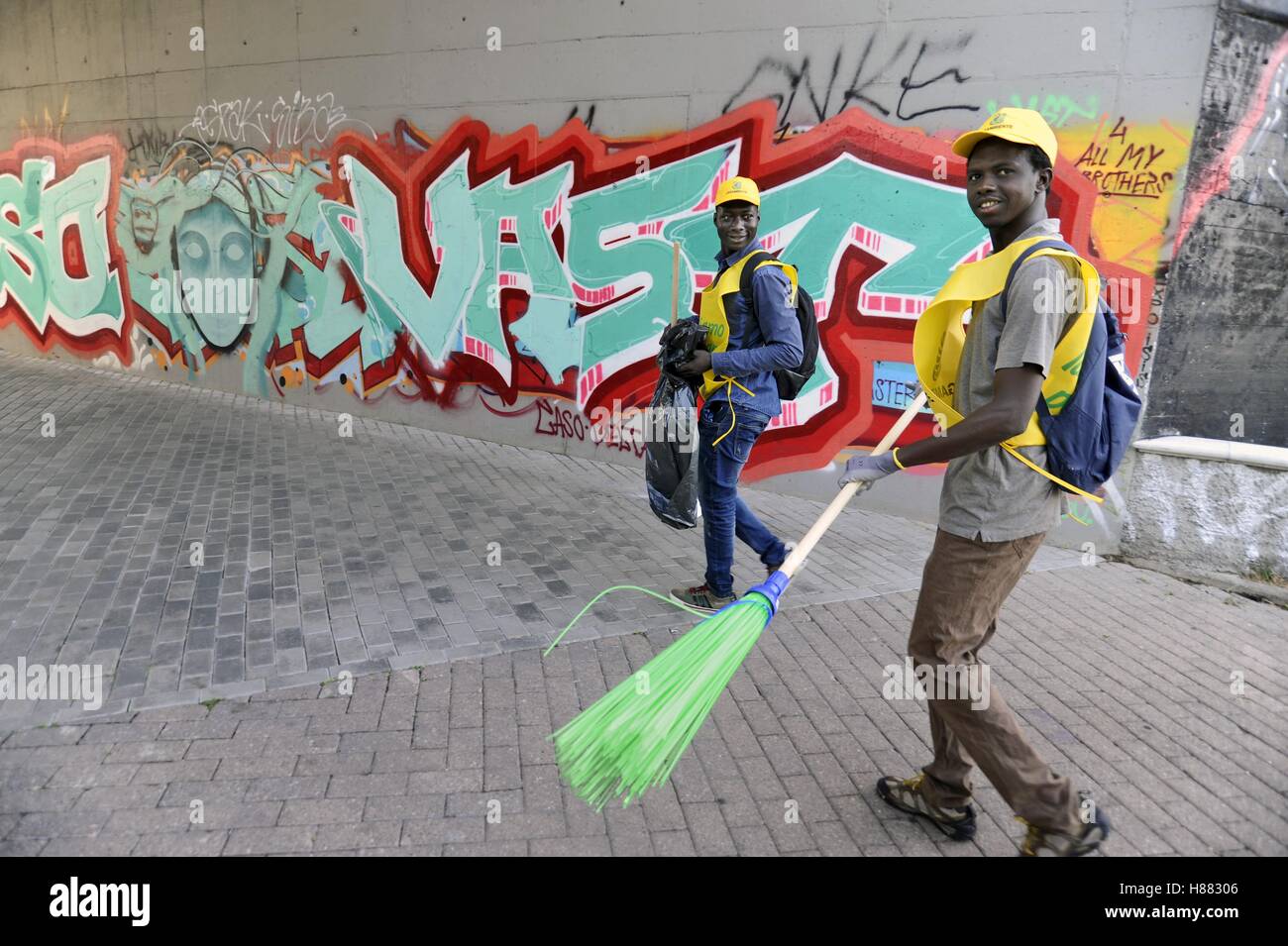 Milan, (Italy), a group of refugees and asylum seekers clean up the ...