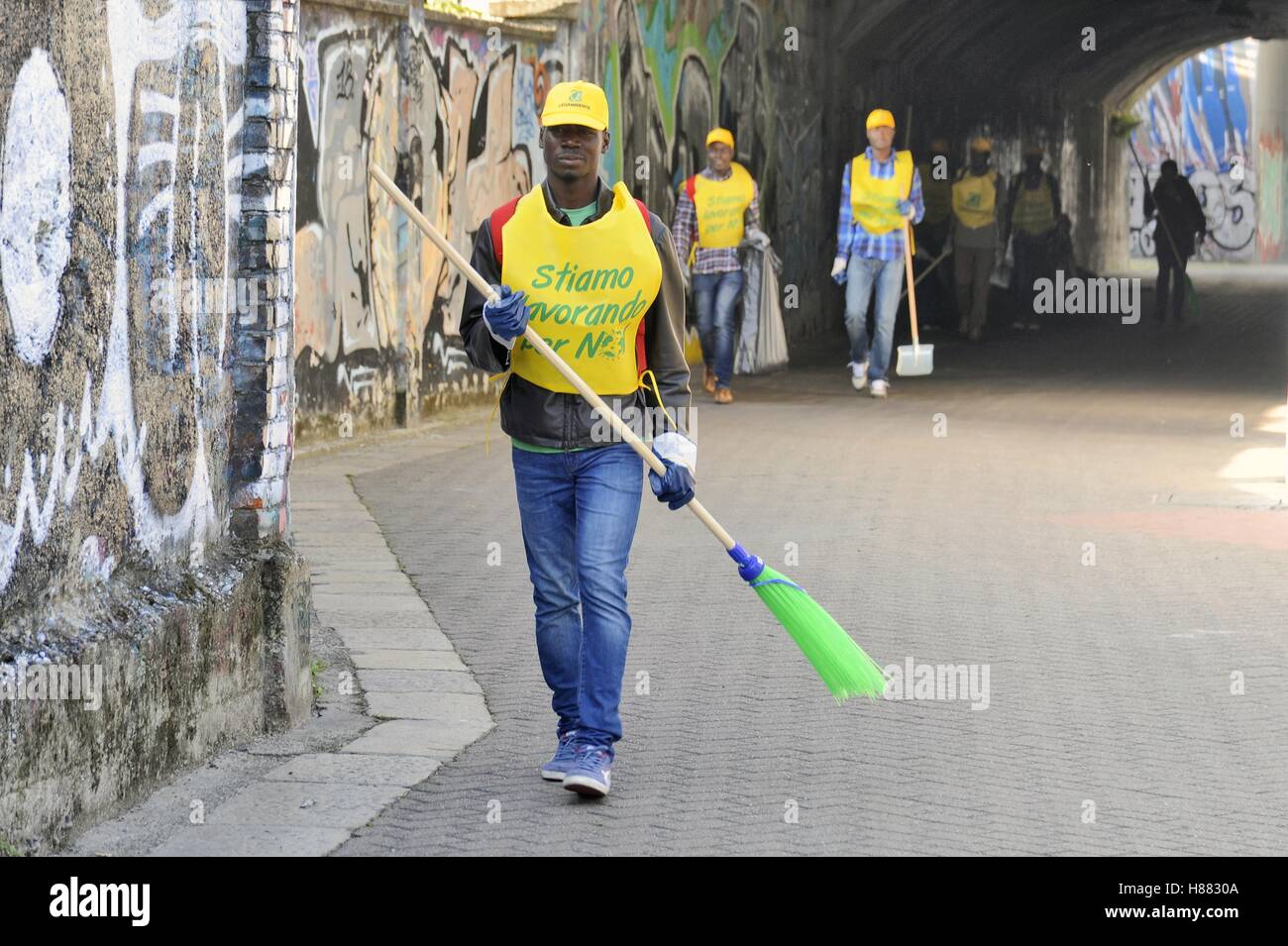 Milan, (Italy), a group of refugees and asylum seekers clean up the ...