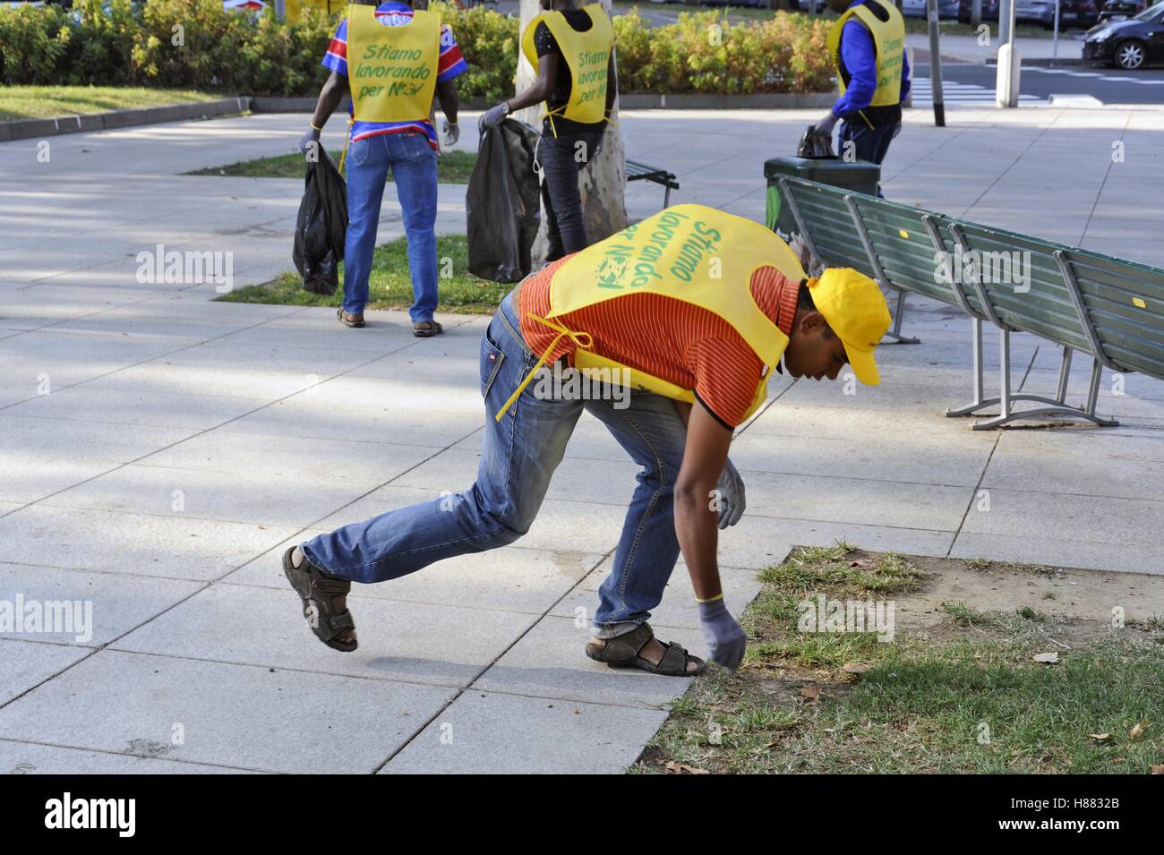 Milan, (Italy), a group of refugees and asylum seekers clean up the ...