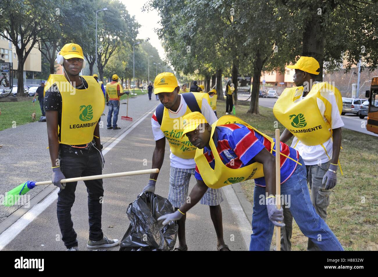 Milan, (Italy), a group of refugees and asylum seekers clean up the ...