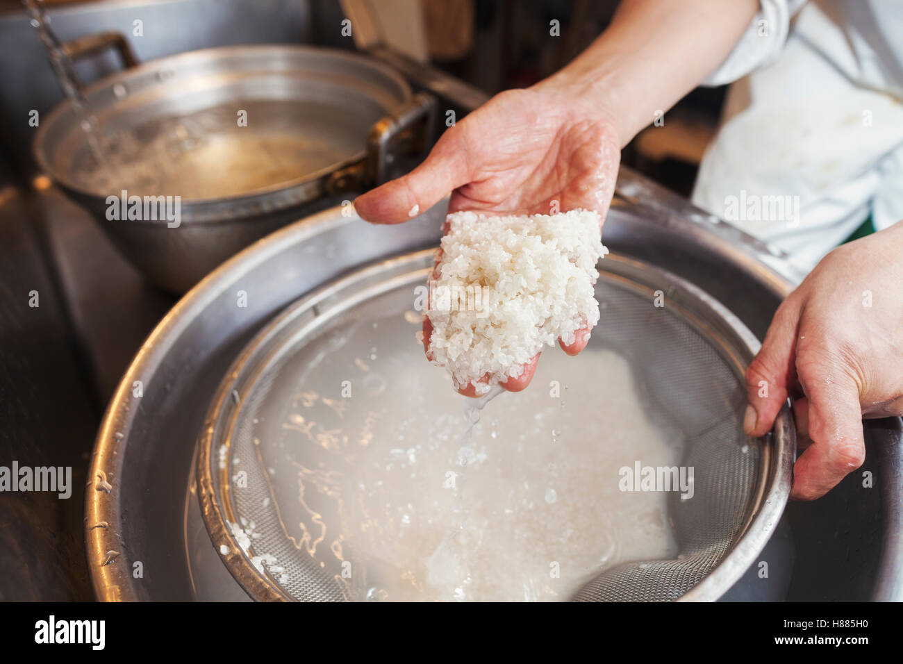 A chef working in a small commercial kitchen, an itamae or master chef ...