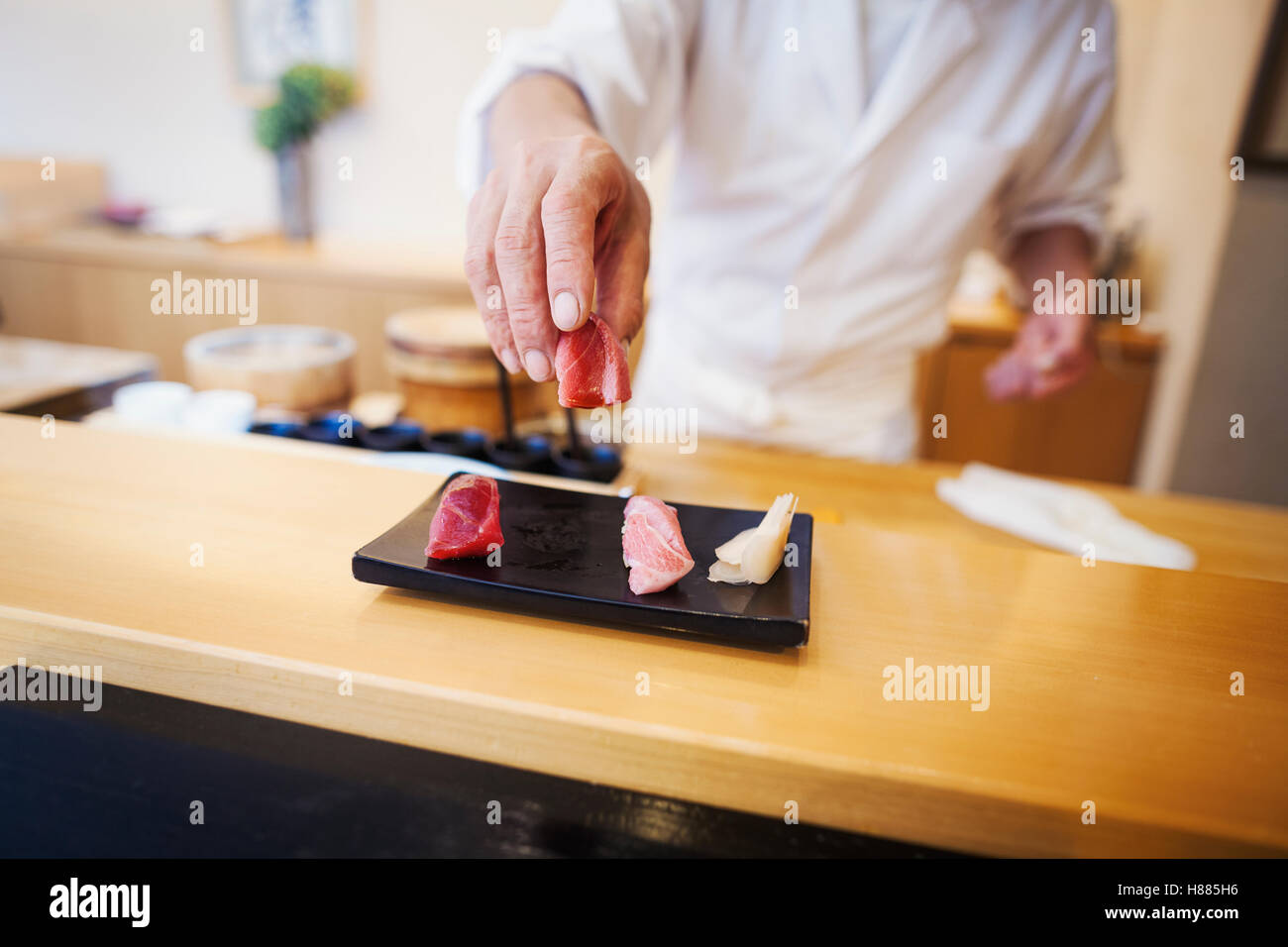 A chef working in a small commercial kitchen, an itamae or master chef ...