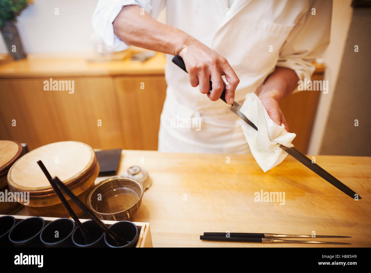A chef working in a small commercial kitchen, an itamae or master chef ...