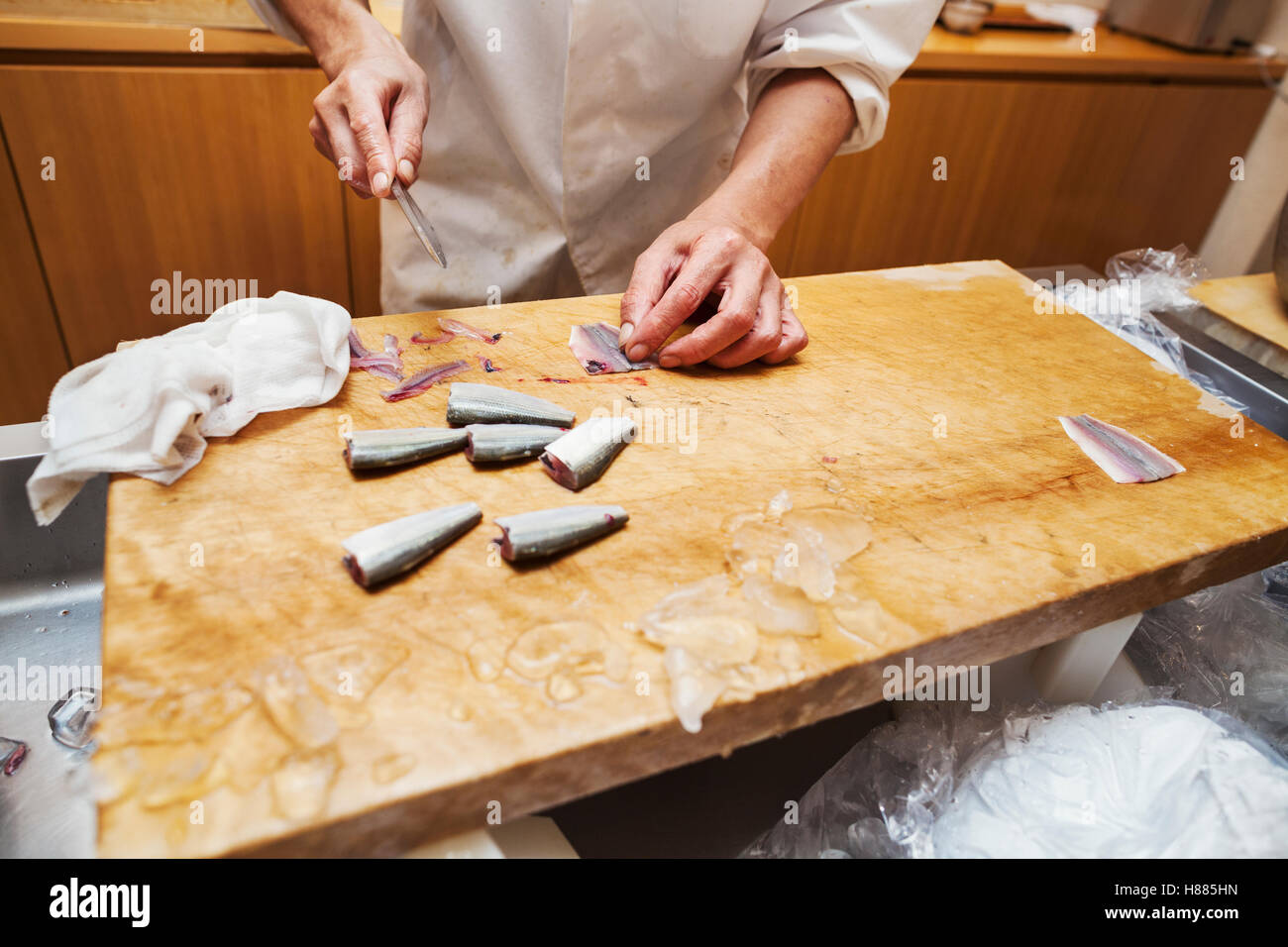 A chef working in a small commercial kitchen, an itamae or master chef ...