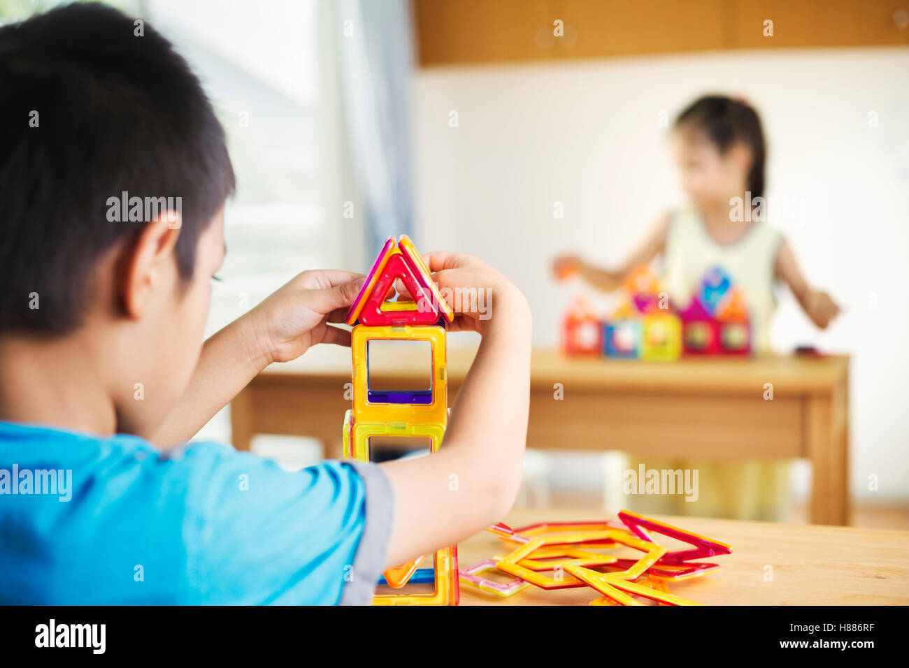 Two children building using geometric shapes Stock Photo - Alamy