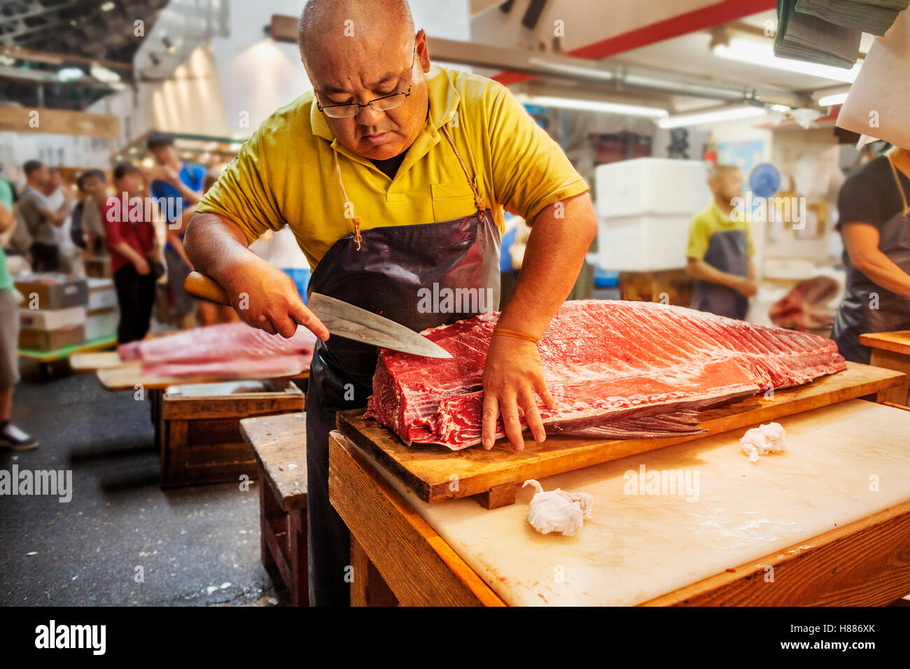 A traditional fresh fish market in Tokyo. A fishmonger working ...