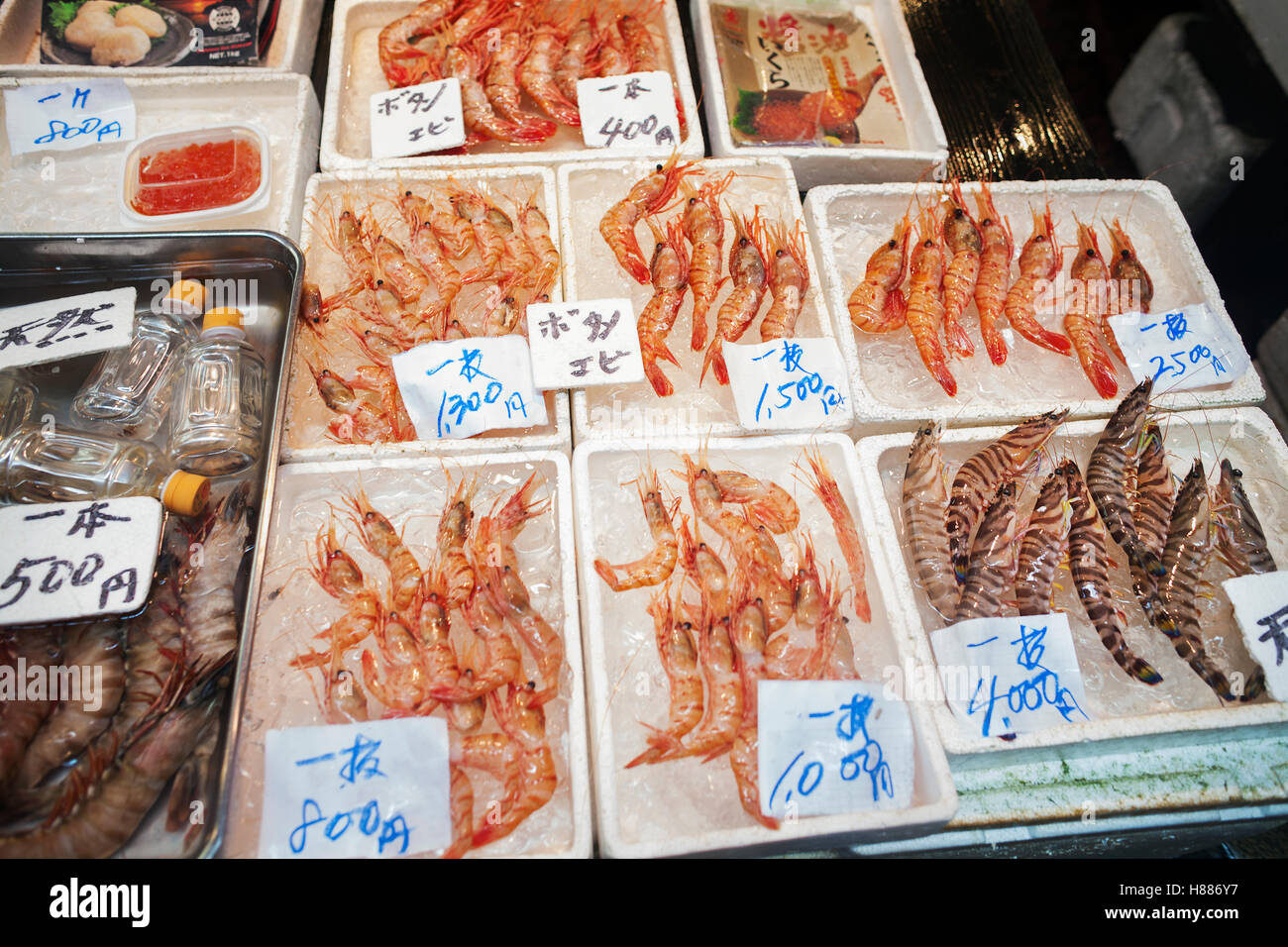 A traditional fresh fish market stall in Tokyo. Fresh and cooked prawns ...