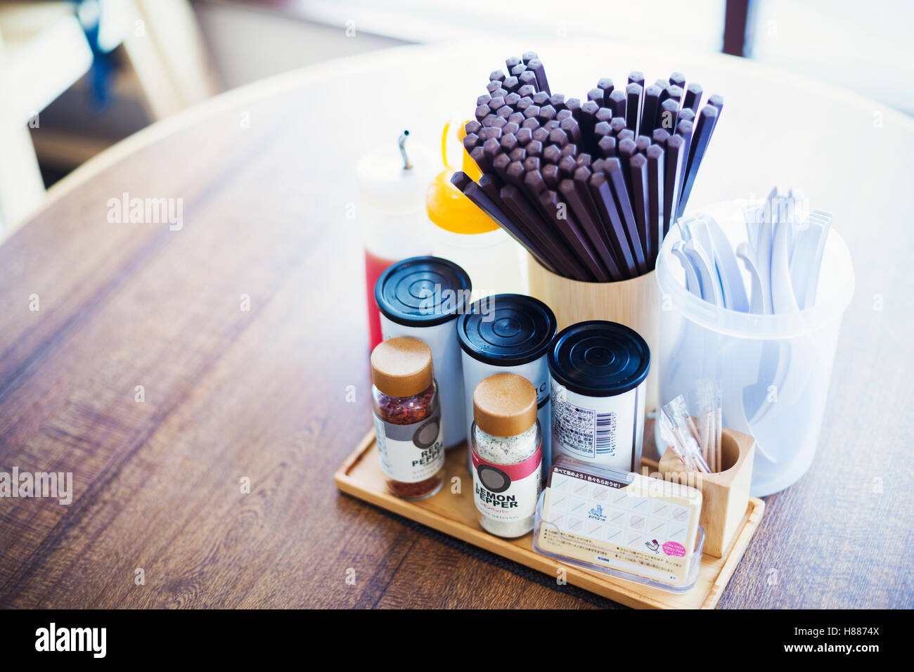 A ramen noodle shop counter with chopsticks and condiments Stock Photo ...
