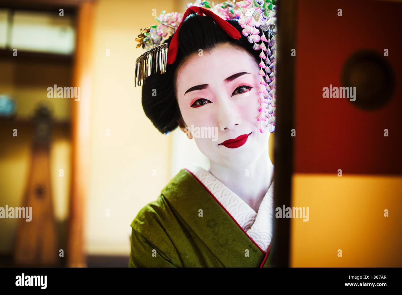 A woman dressed in the traditional geisha style, wearing a kimono and ...