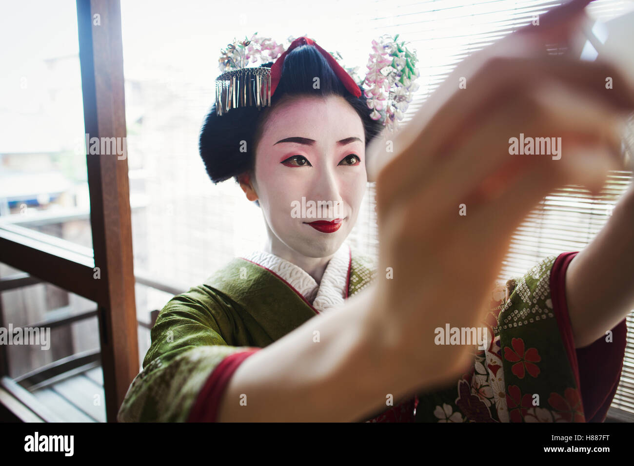 A woman dressed in the traditional geisha style, wearing a kimono and ...