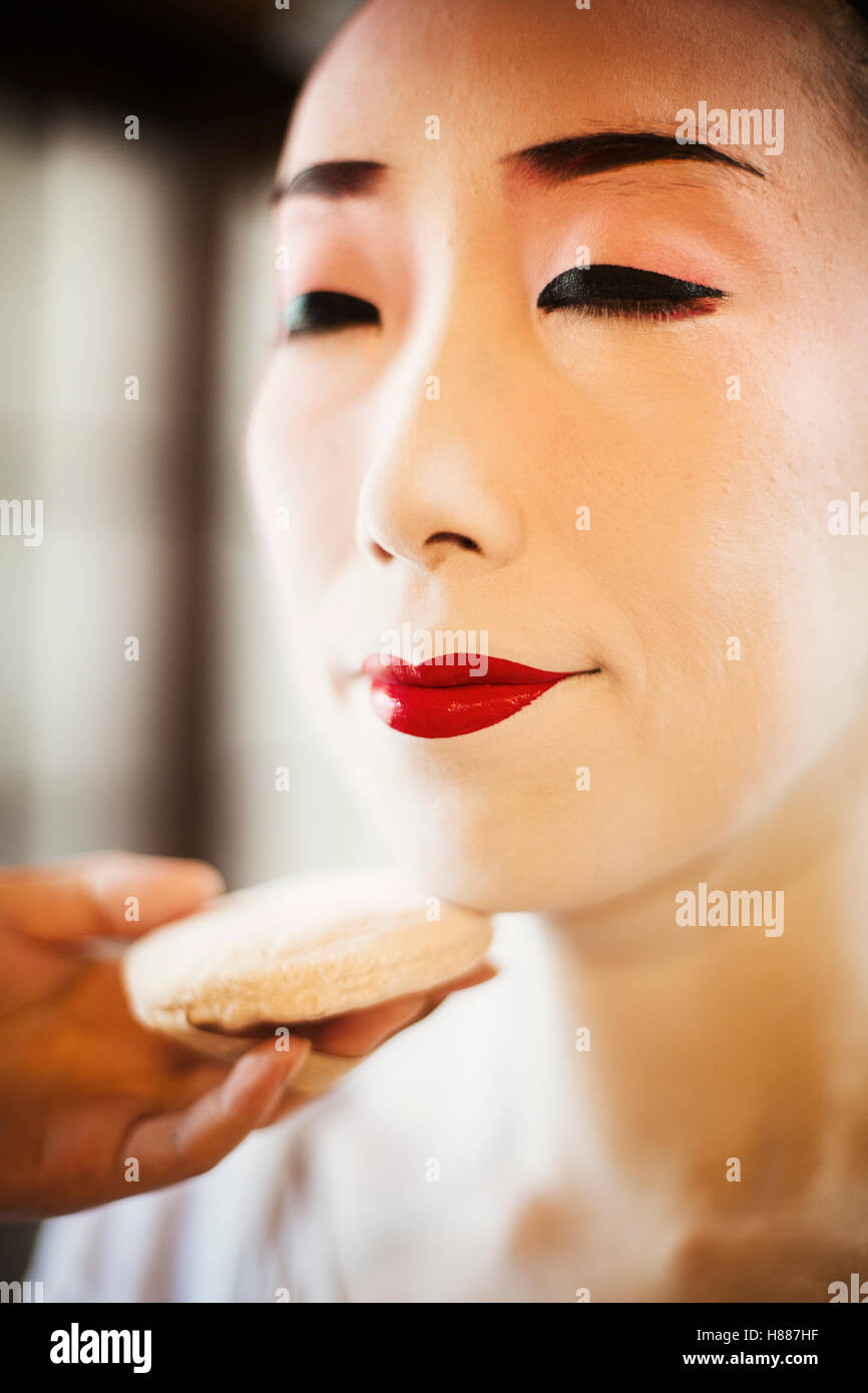 A modern woman creating the traditional geisha vivid red lips by ...