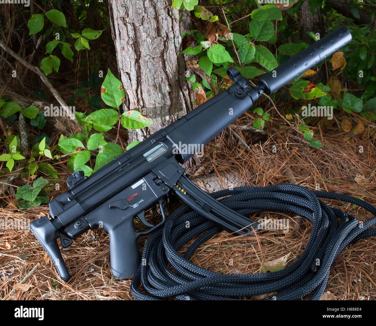 Assault rifle with a collapsible stock and suppressor Stock Photo - Alamy