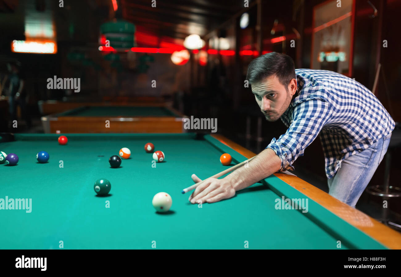 Handsome man playing pool in pub Stock Photo - Alamy