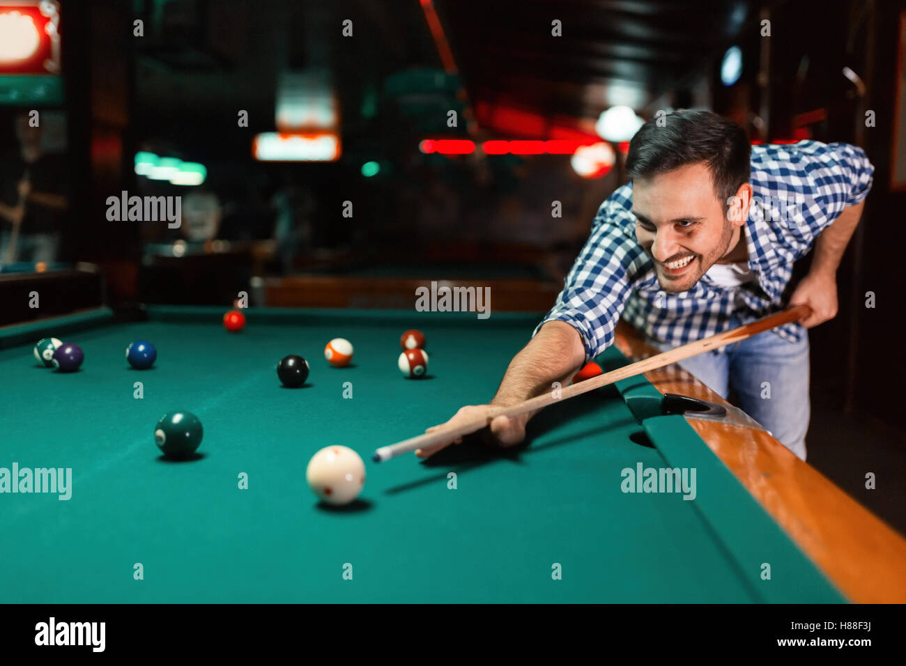 Handsome man playing pool in pub Stock Photo - Alamy