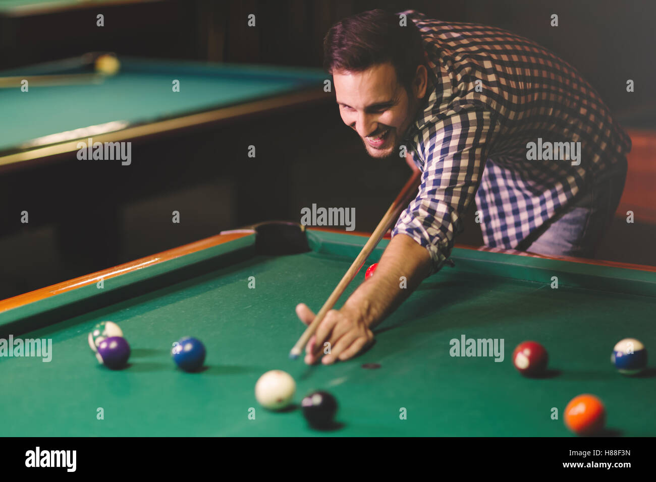 Handsome man playing pool in pub Stock Photo - Alamy
