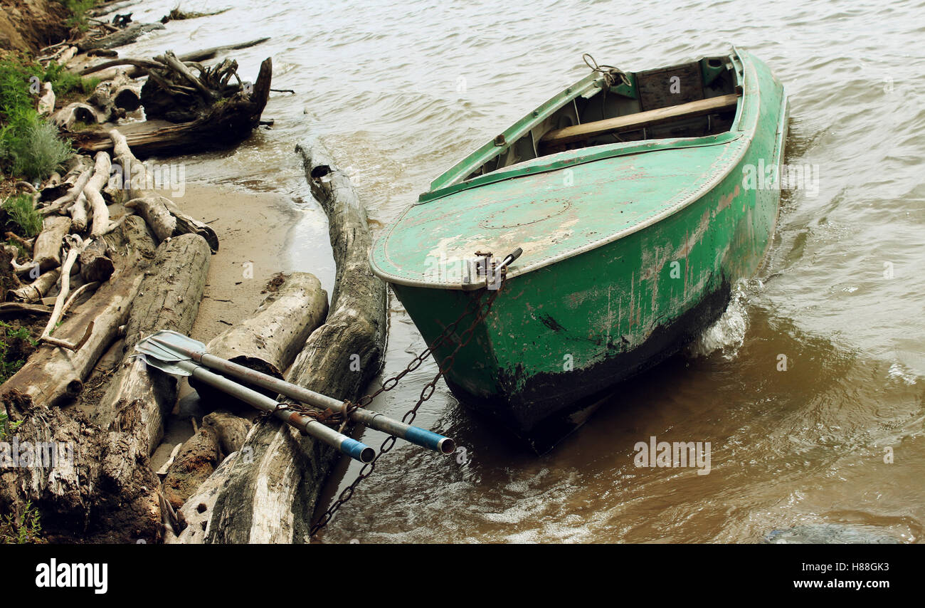 Old green boat with oars on the coast Stock Photo - Alamy