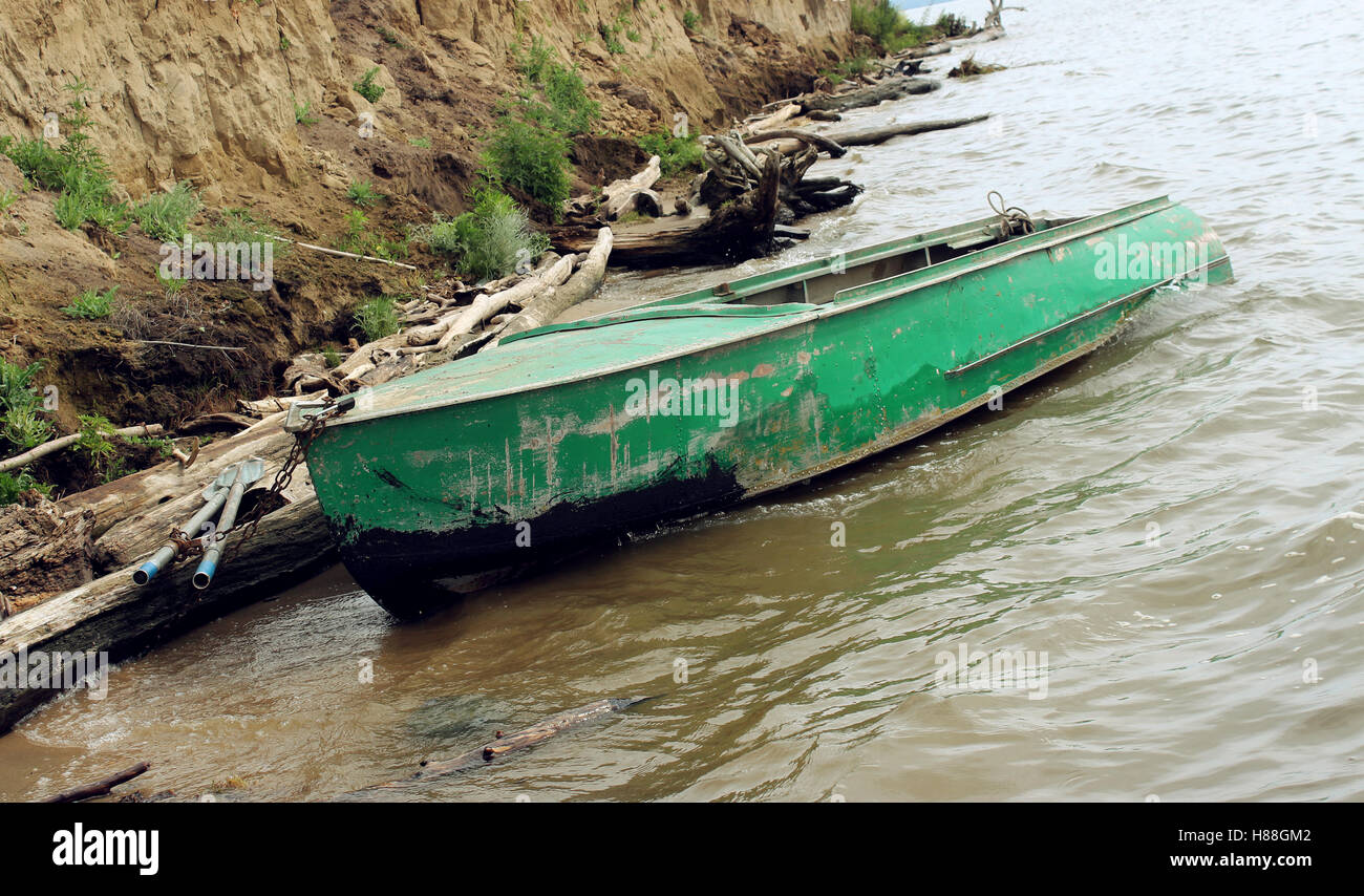 Old green boat with oars on the coast Stock Photo - Alamy
