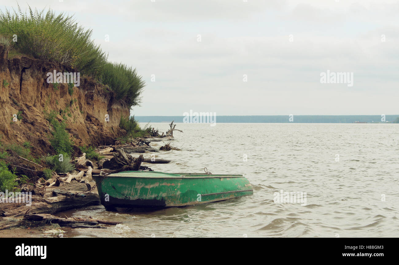 Old green boat with oars on the coast Stock Photo - Alamy