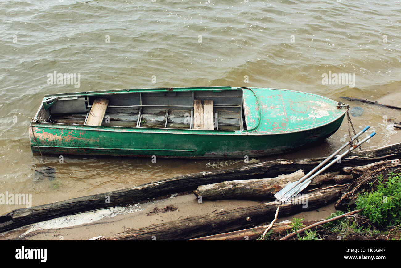 Old green boat with oars on the coast Stock Photo - Alamy