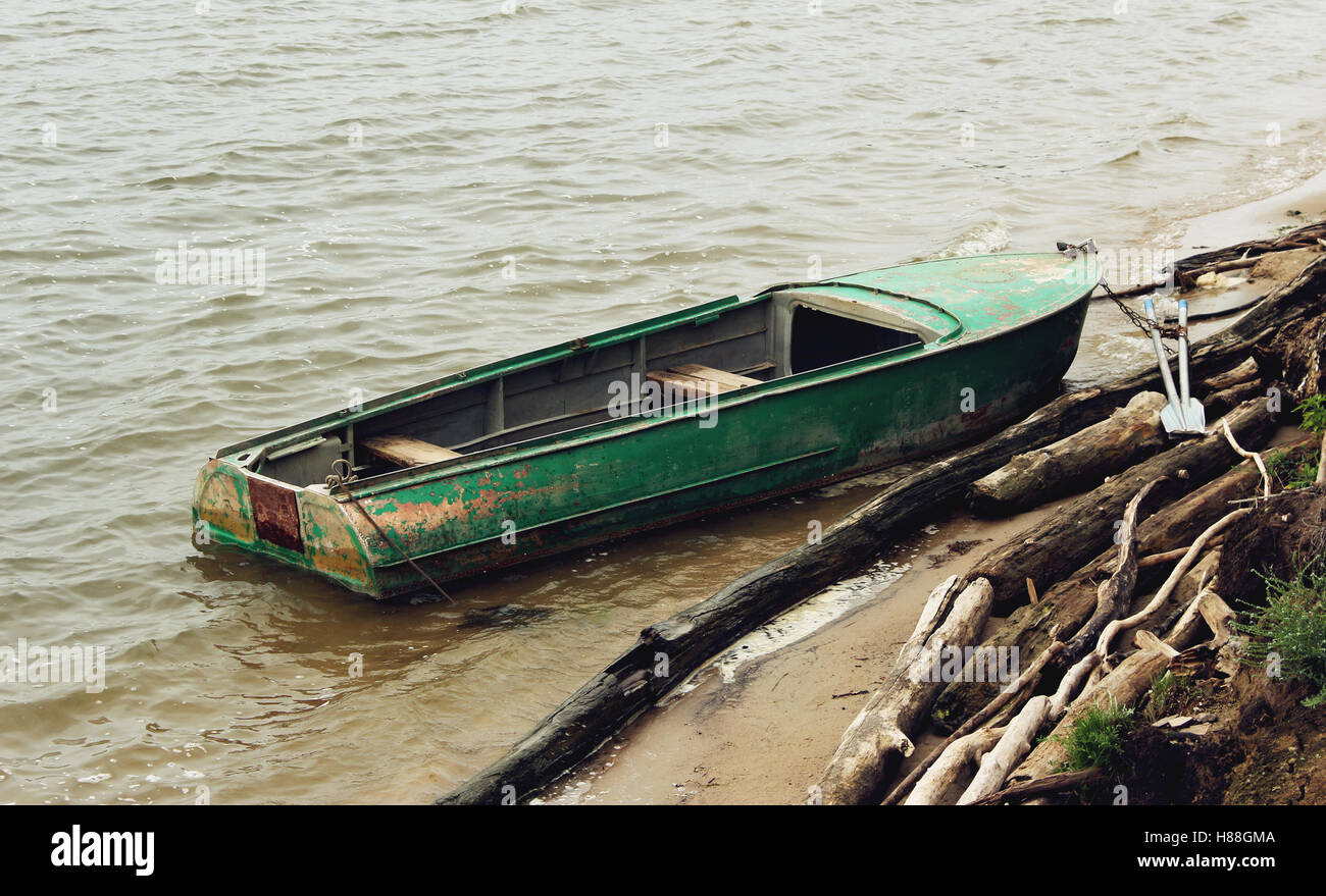 Old green boat with oars on the coast Stock Photo - Alamy