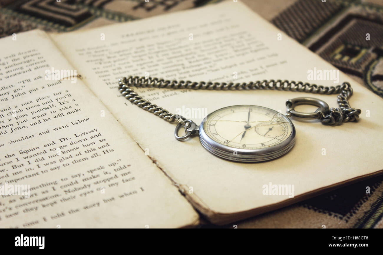 Old pocket watch on the book Stock Photo - Alamy