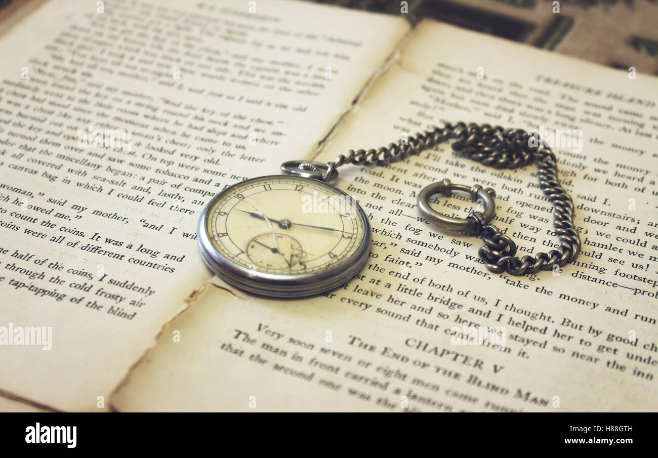 Old pocket watch on the book Stock Photo - Alamy
