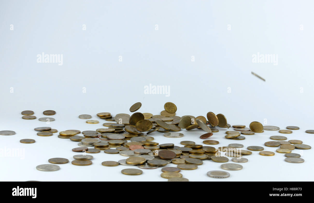 Coins fall into a pile Stock Photo - Alamy