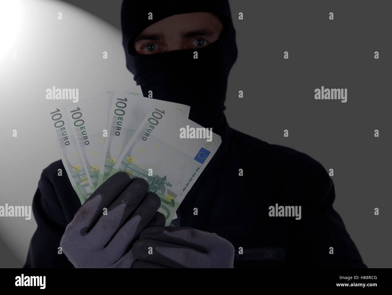Burglar holding money Stock Photo - Alamy