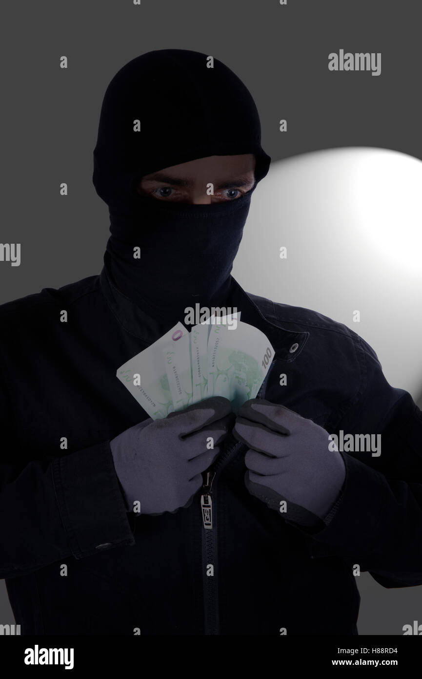 Burglar holding money Stock Photo - Alamy