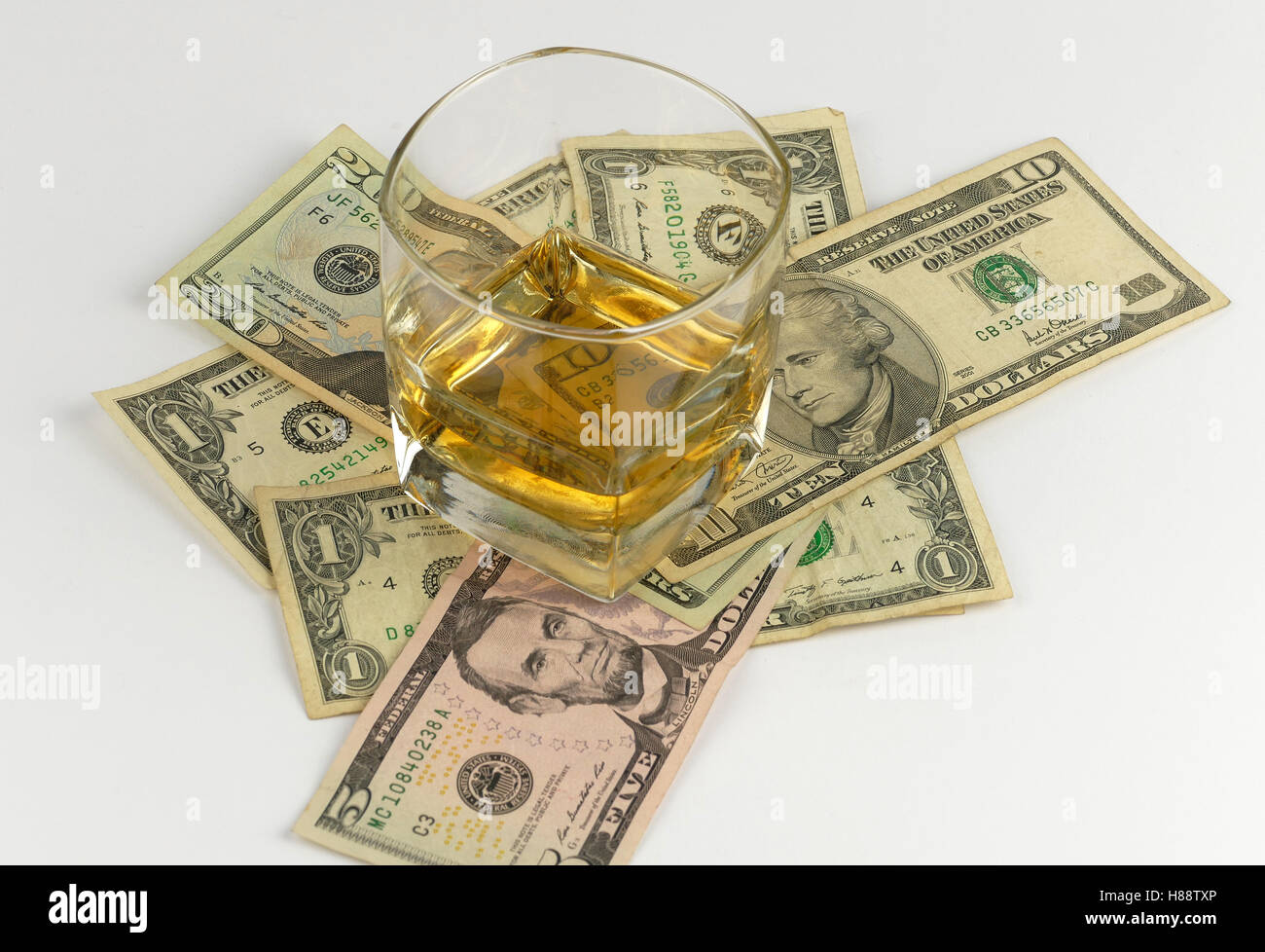 Glass of alcohol drink with money isolated on white background Stock ...