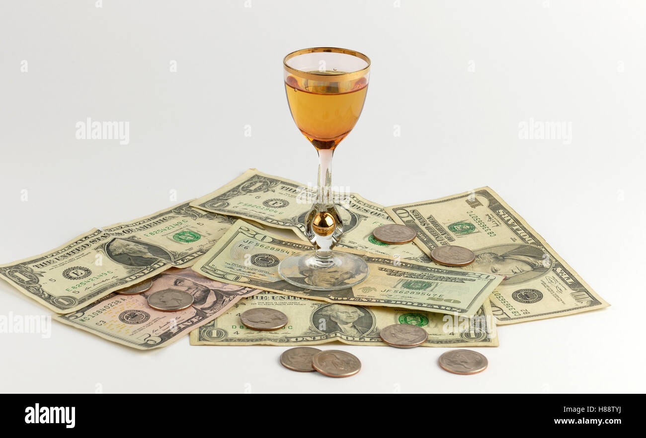 Glass of alcohol drink with money isolated on white background Stock ...